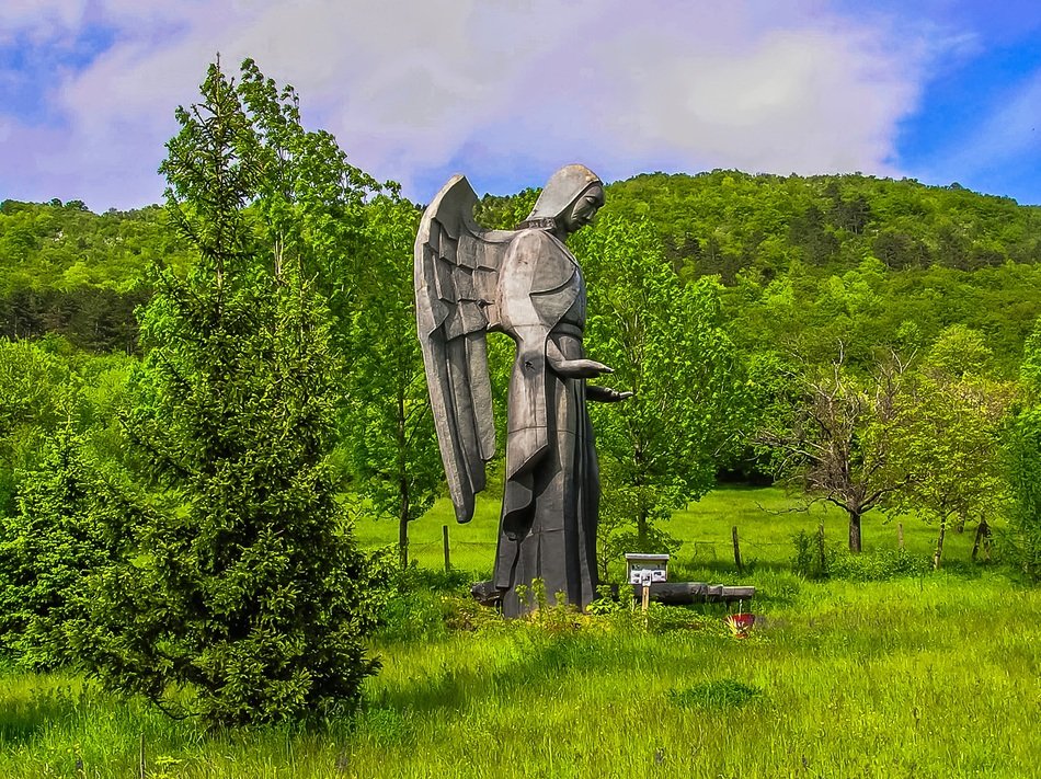 Angel statue in green summer landscape free image download