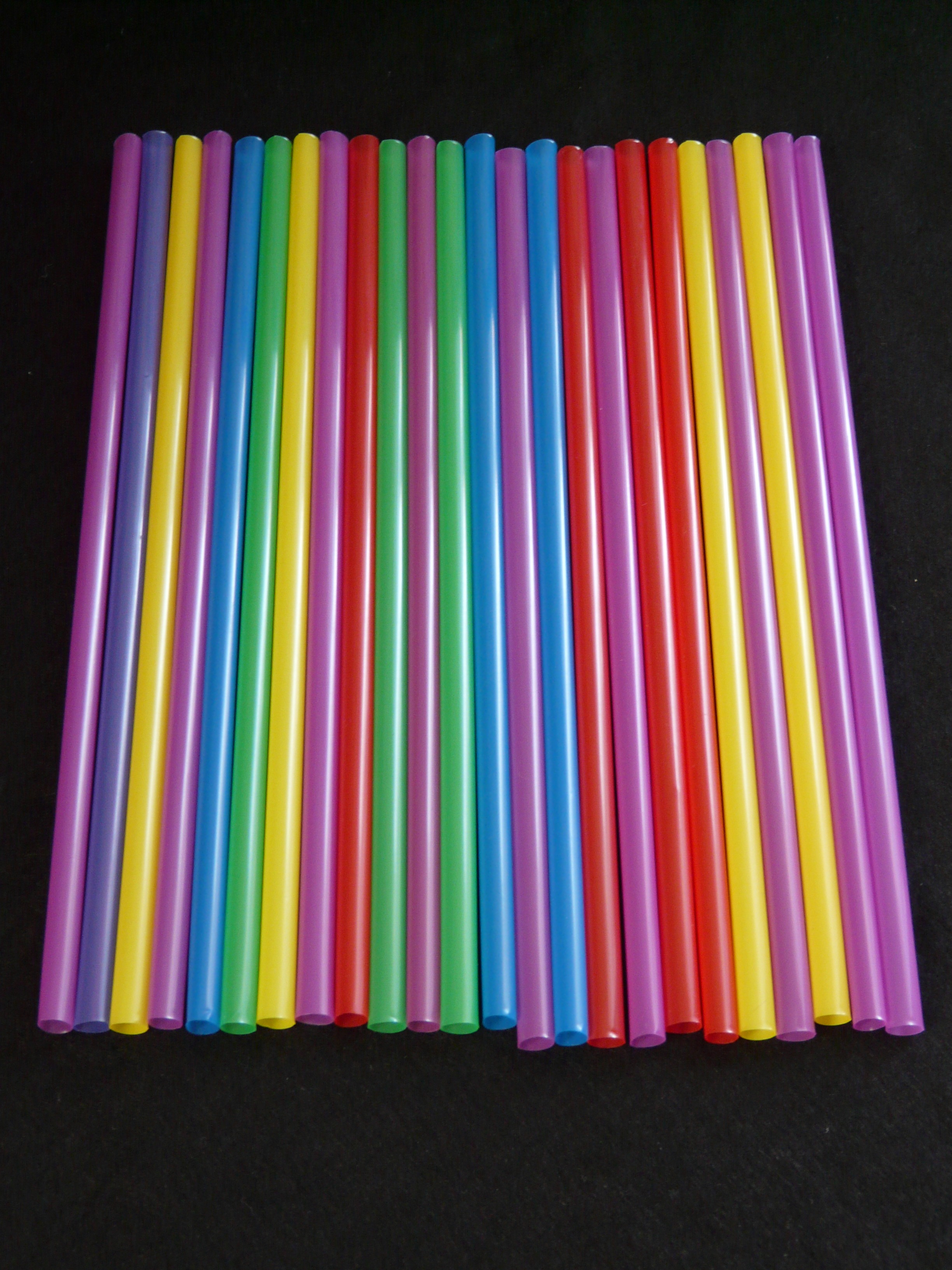 Colorful plastic straws on a black background free image download