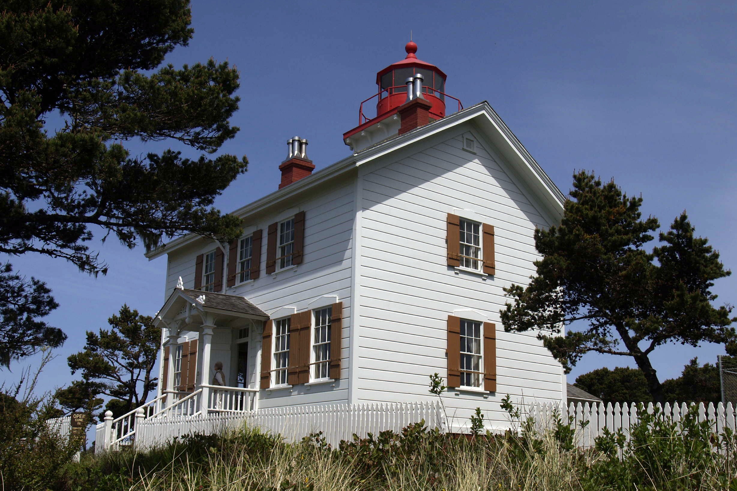 Building with a lighthouse on the coastline free image download