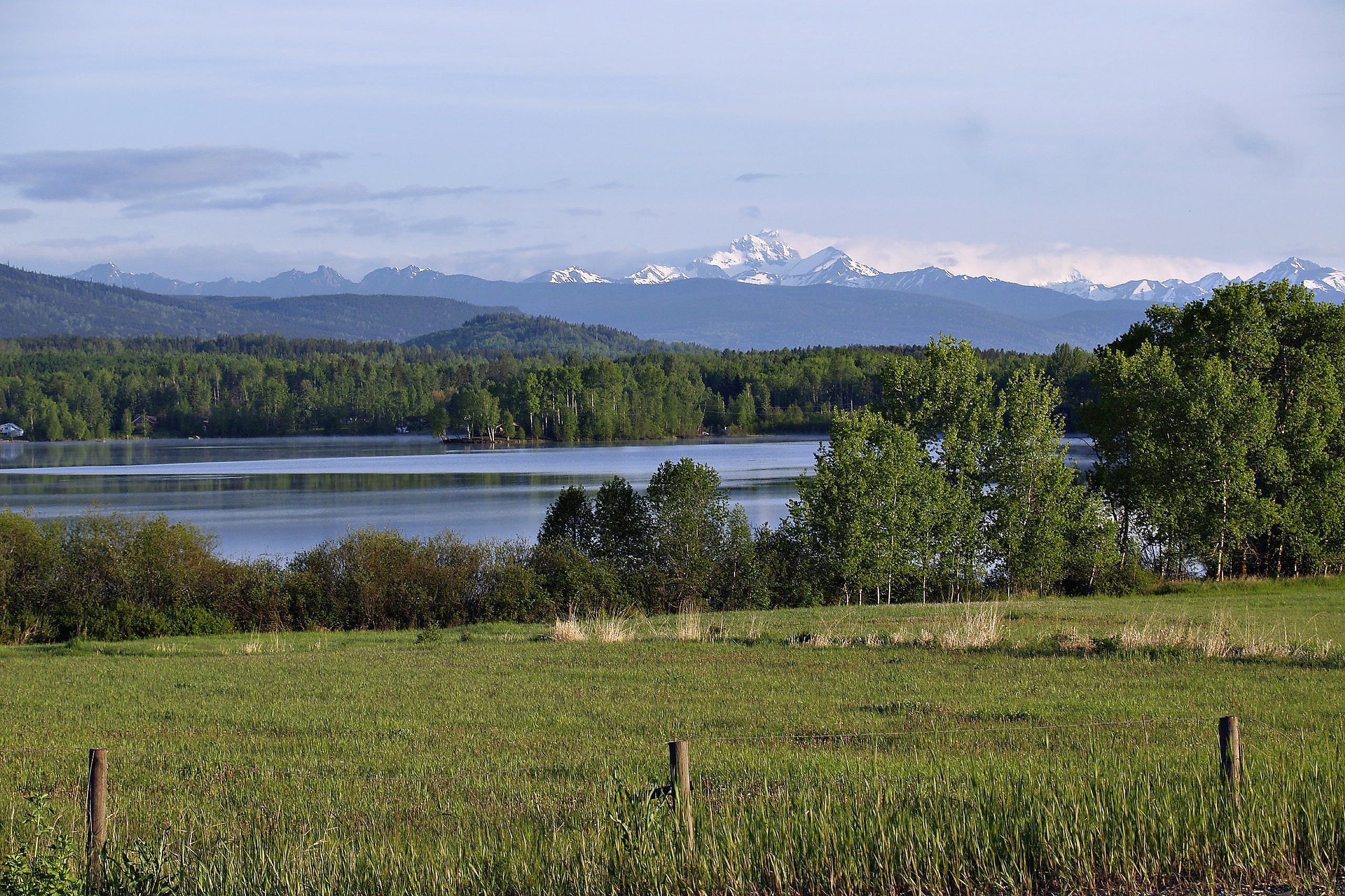 Landscape photo of green forest and green fields by the river in Canada ...