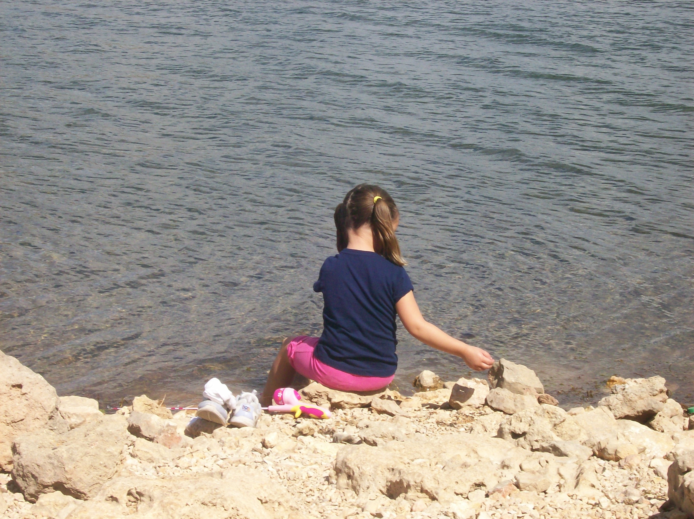 Child on stones near the water free image download