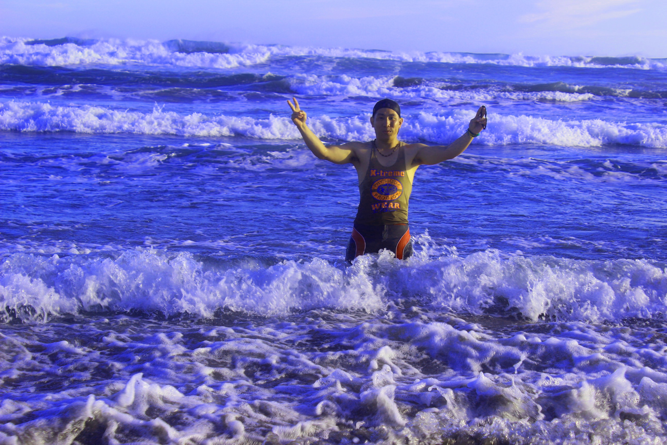 Man standing in the waves of the ocean free image download