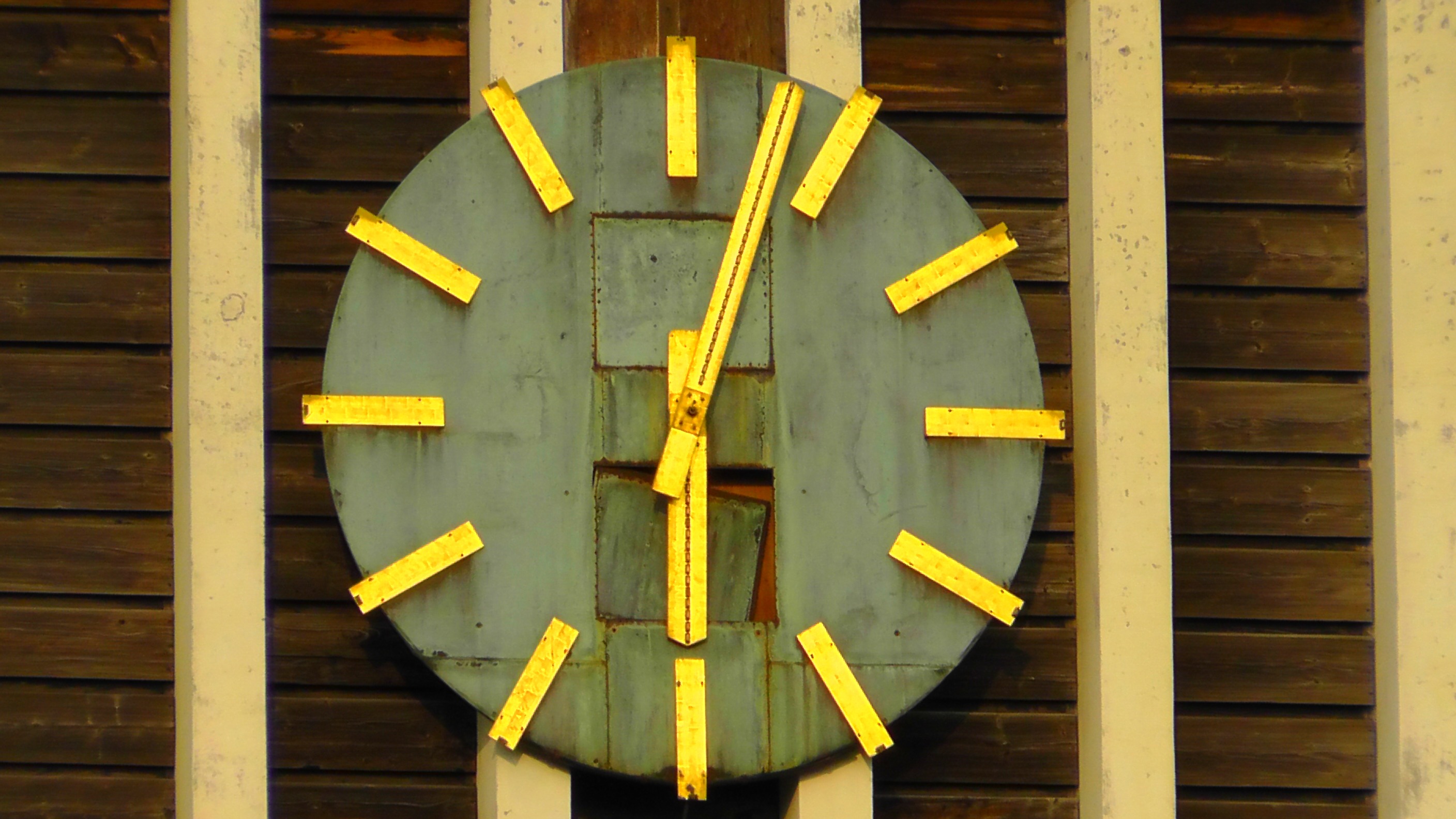 Clock with a gold dial on the facade of the building free image download