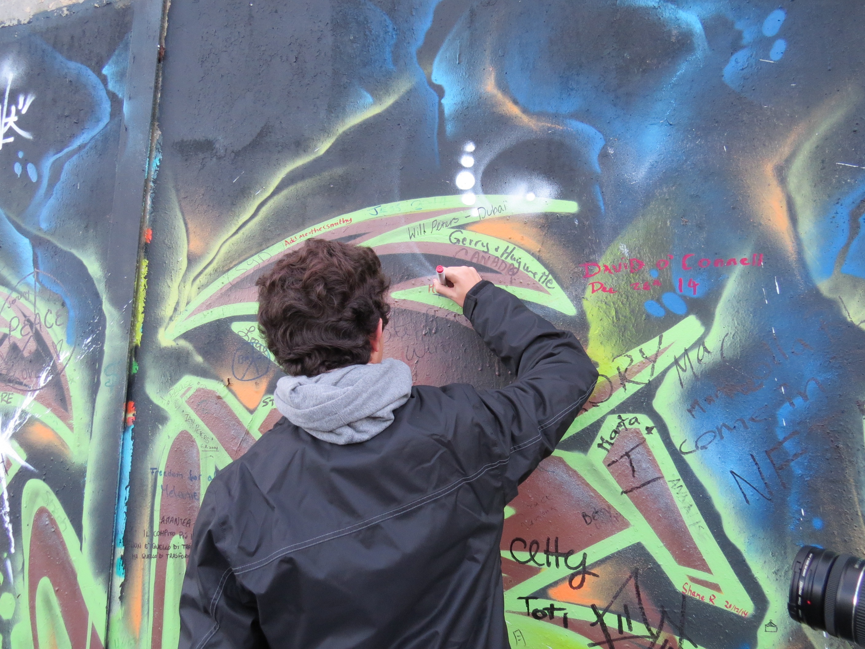 Young man draws graffiti on the urban wall free image download