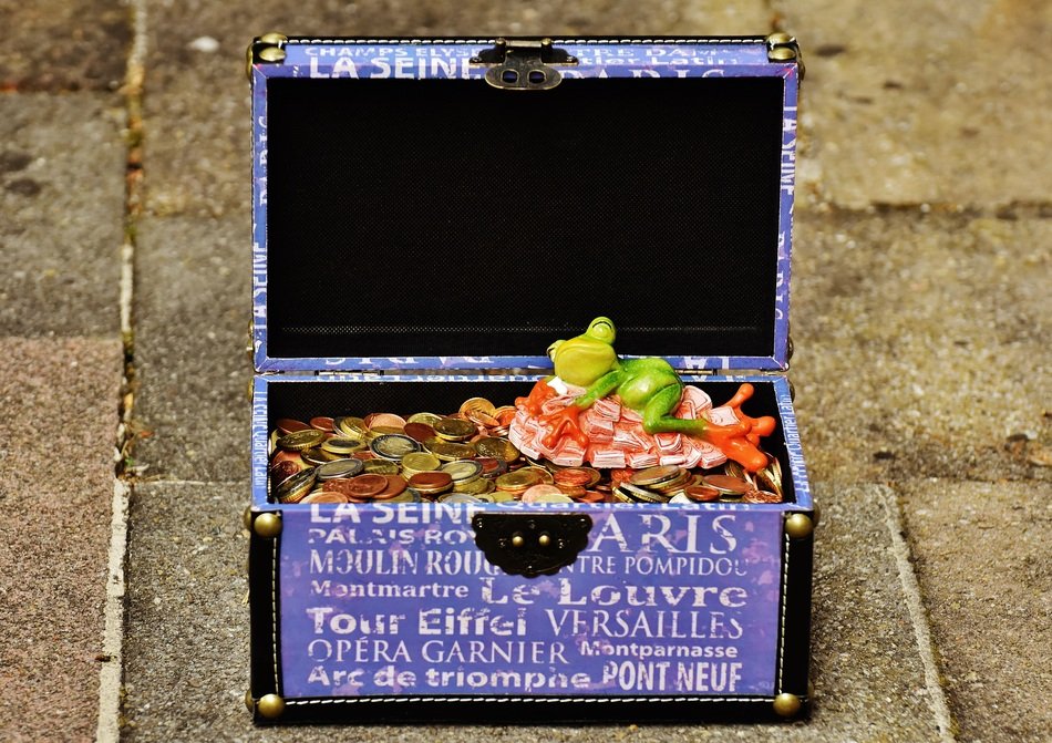 Figurine frog lies in a chest with coins free image download