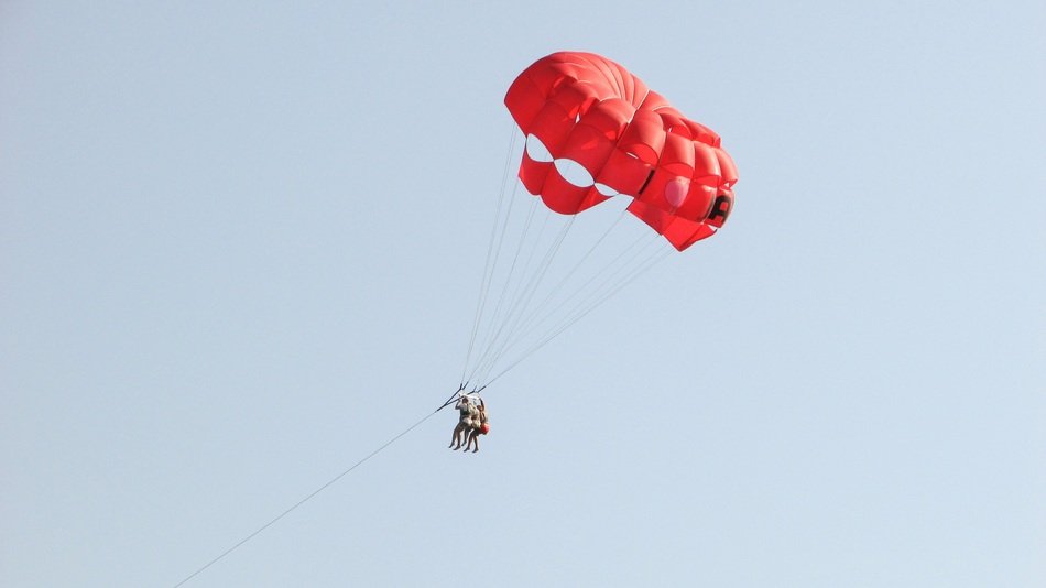 Red parachute with two paragliders free image download