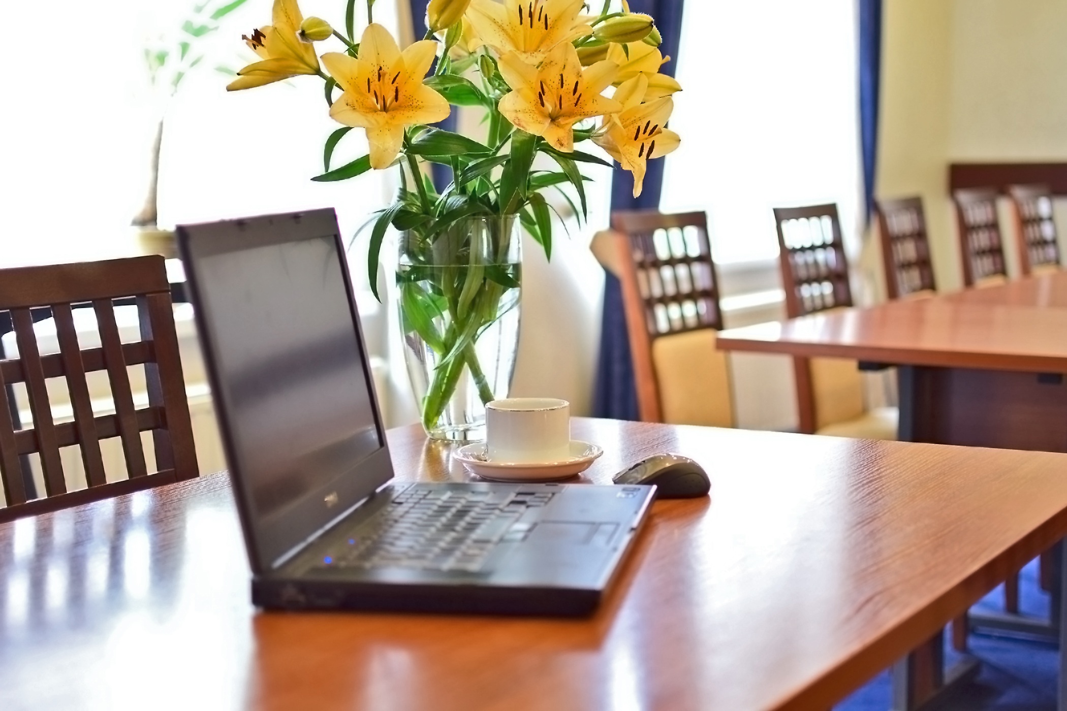 Laptop and a bouquet of flowers on the table in the conference room ...