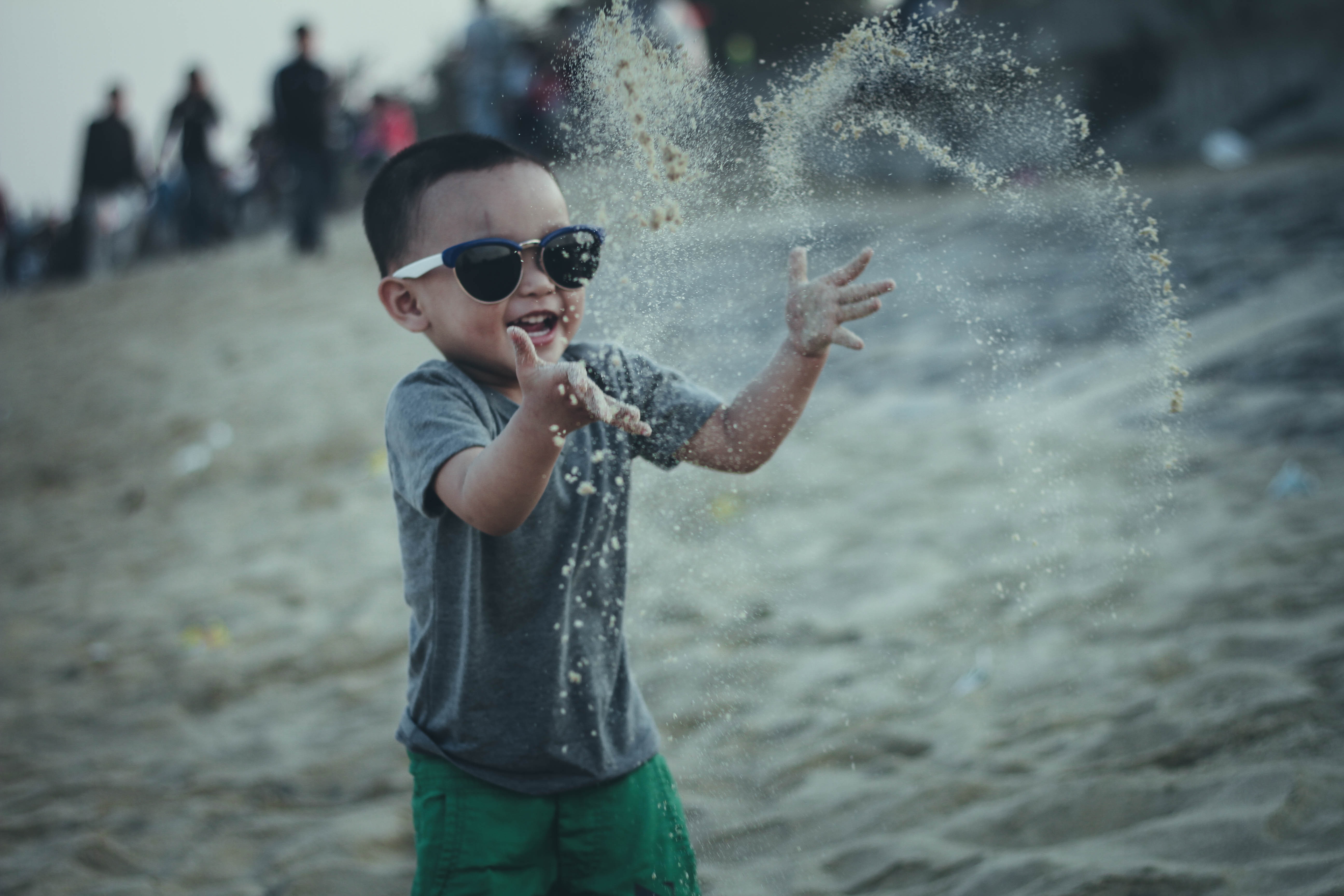 Boy throws sand on the beach free image download