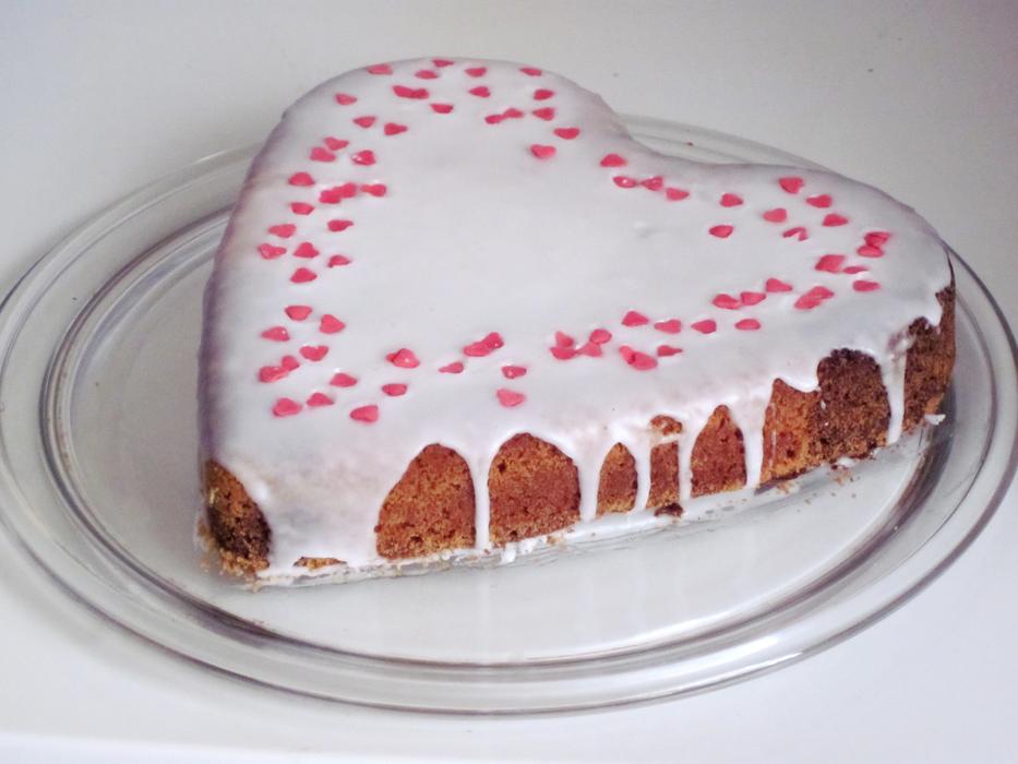 Beautiful heart cake with cream and pink hearts, on the glass plate ...