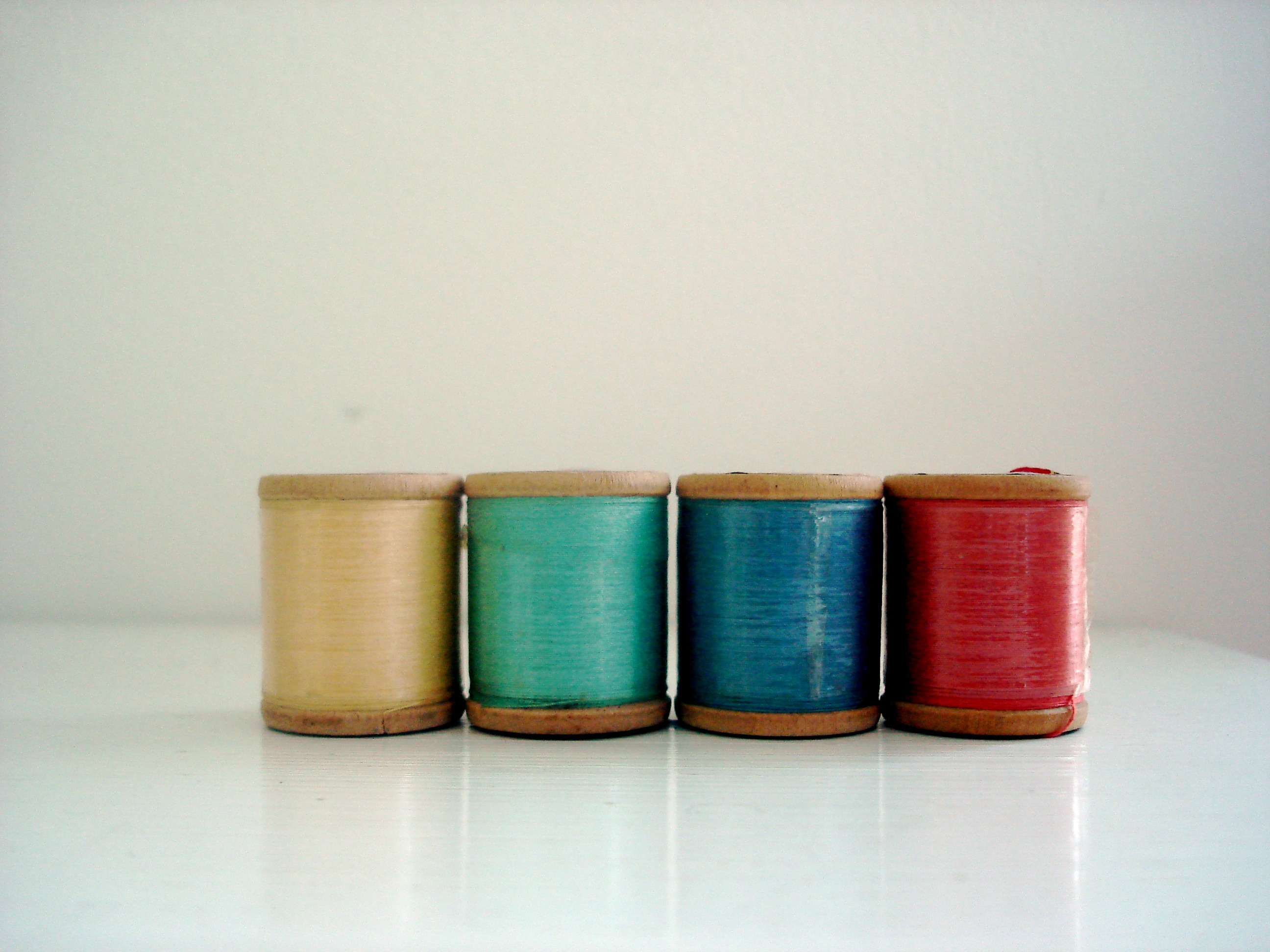 Colorful and beautiful threads on the spools, on the white surface with ...
