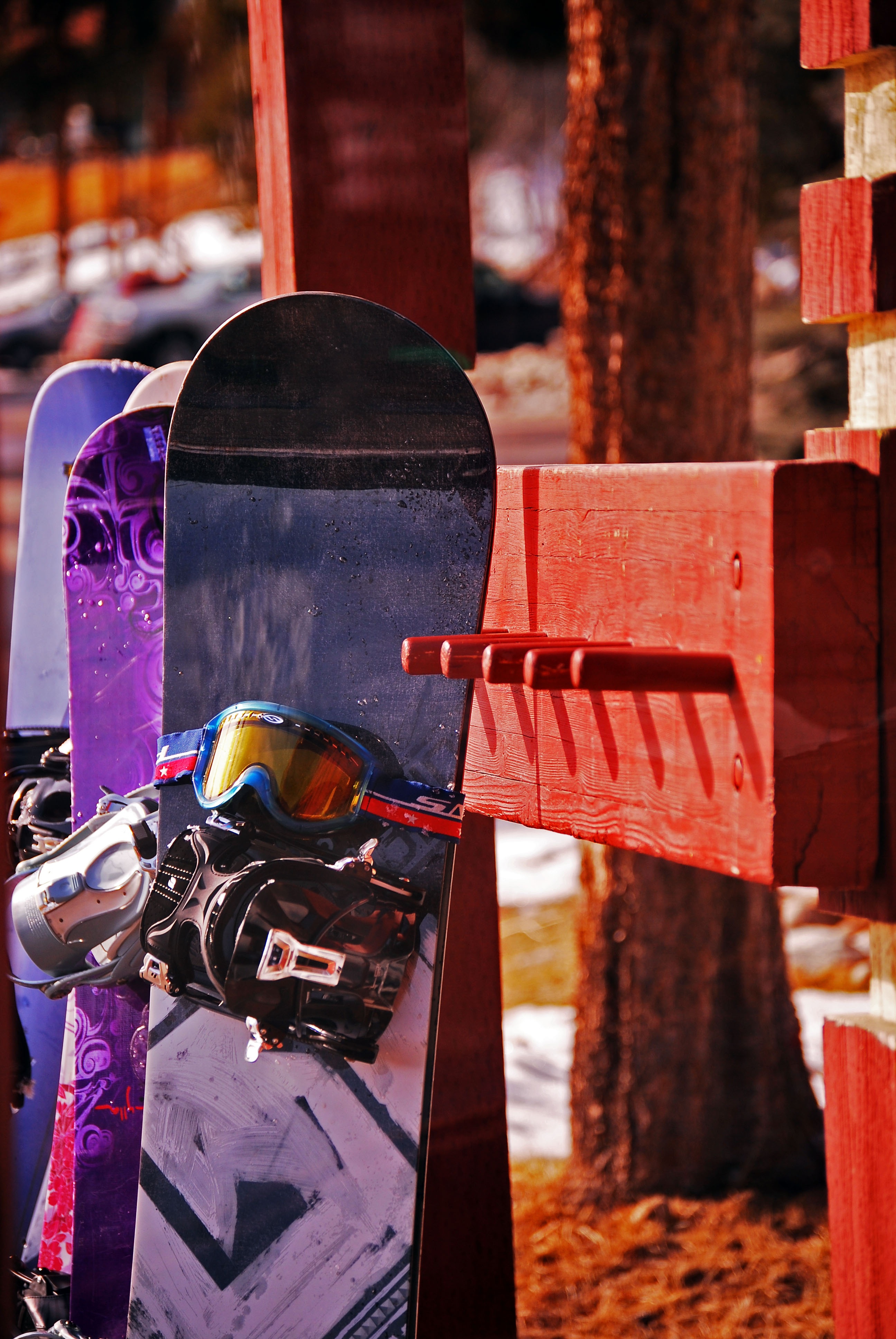 A snowboard stands near a wooden fence free image download