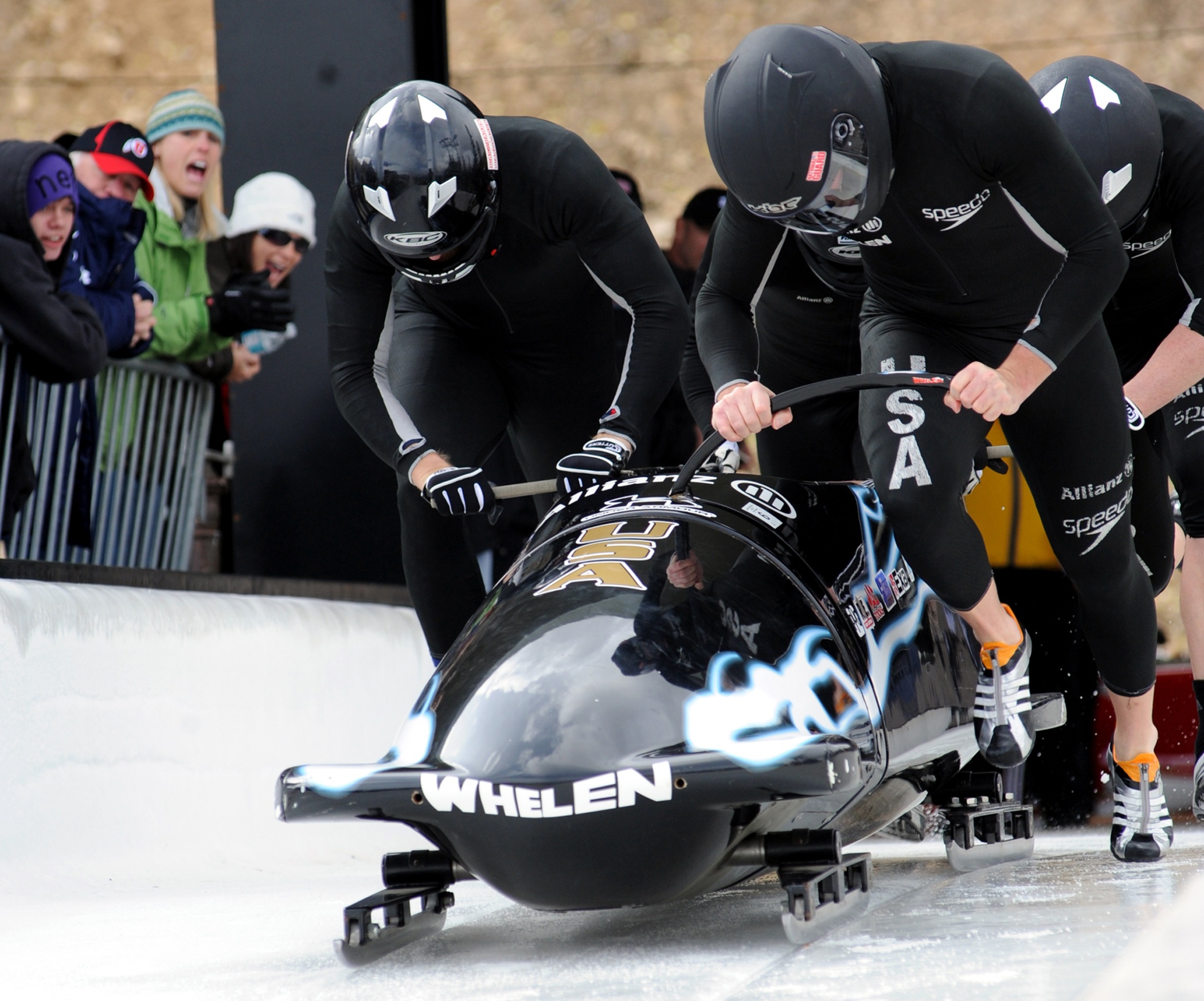 Bobsled team in equipment, on the competition with spectators free ...