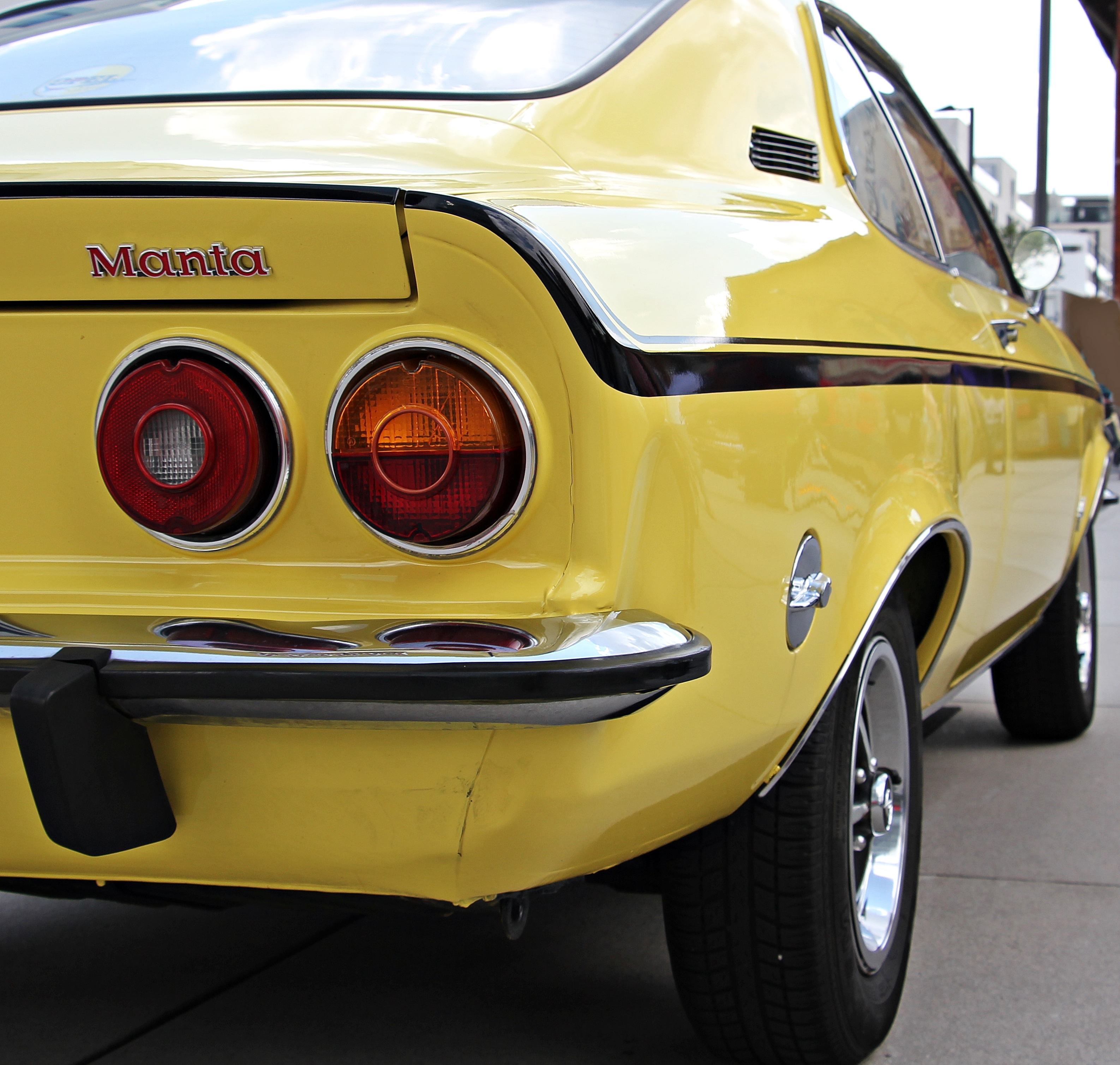 Back view of the shiny, beautiful, vintage yellow "Manta" car, in light ...