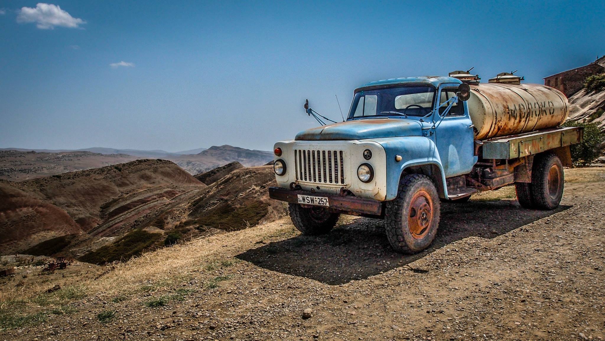 Milk truck is parked near the cliff free image download