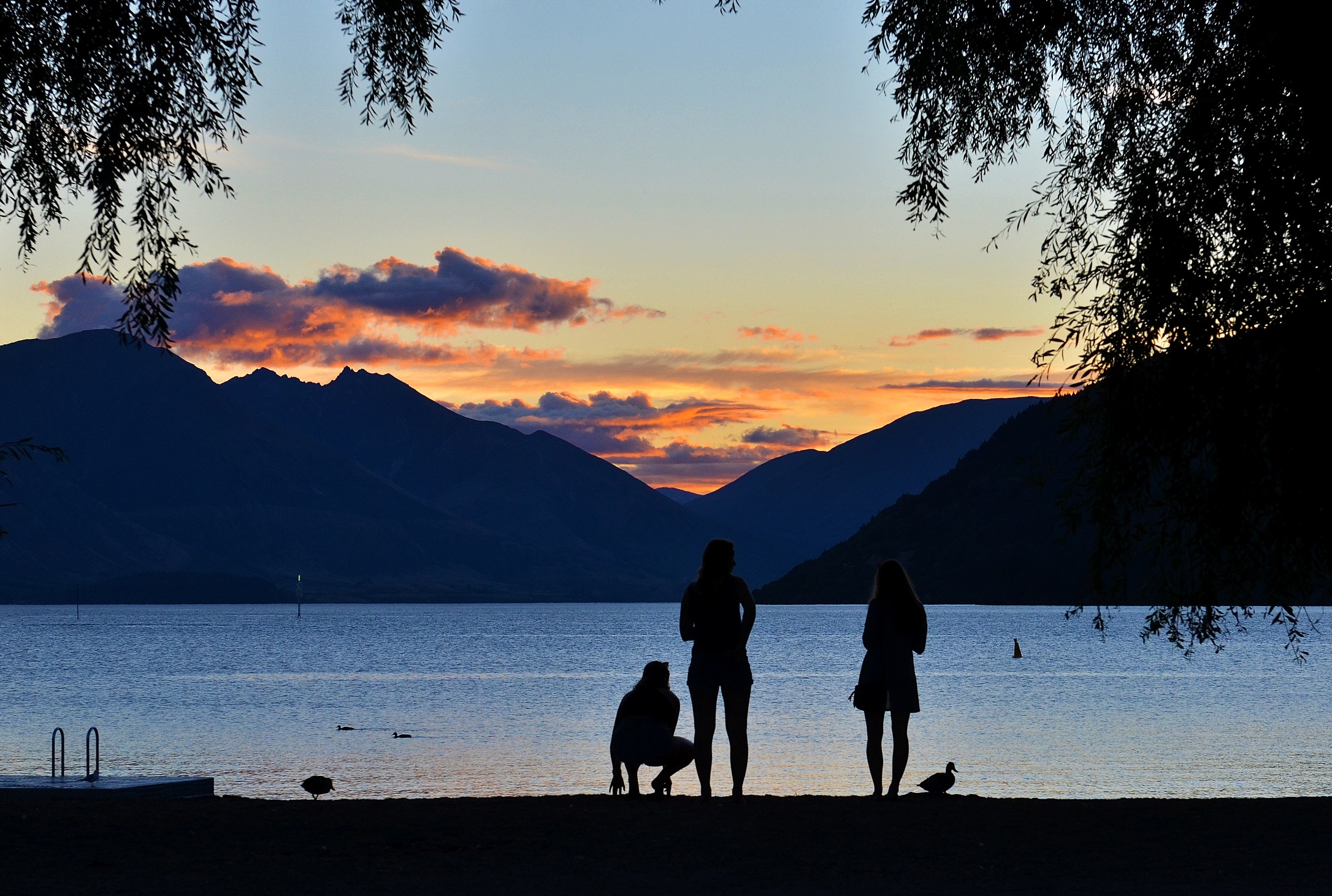 Three people at sunset on the beach free image download