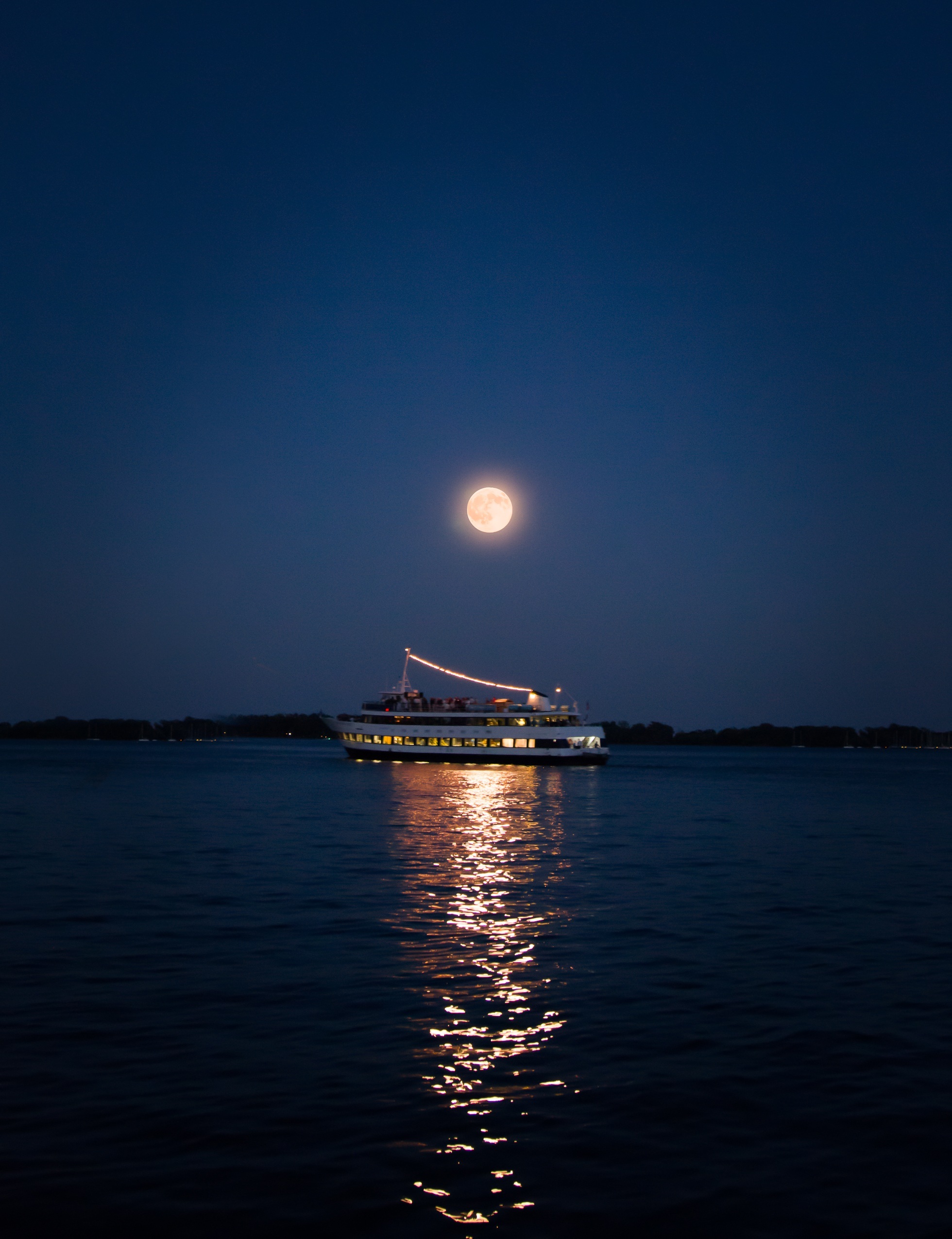 Tourist boat beneath fool moon on Sea at night free image download