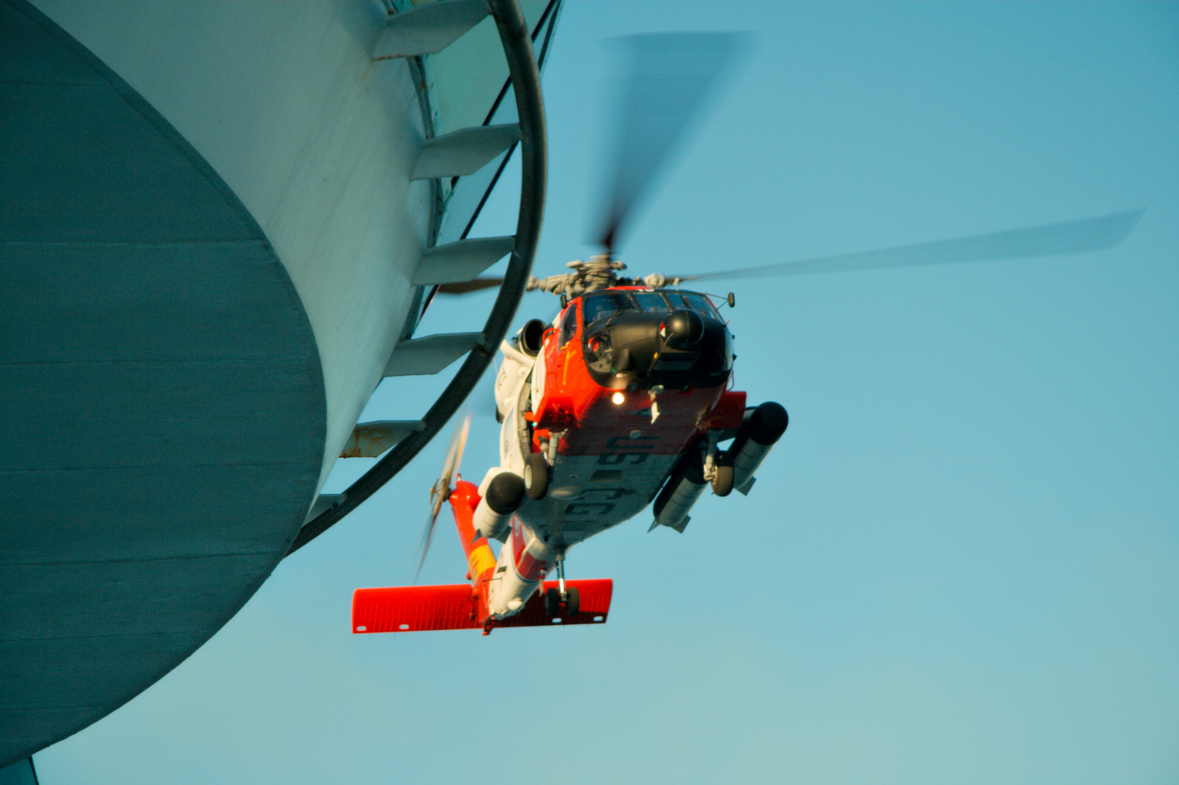 Military helicopter flying near the ship free image download