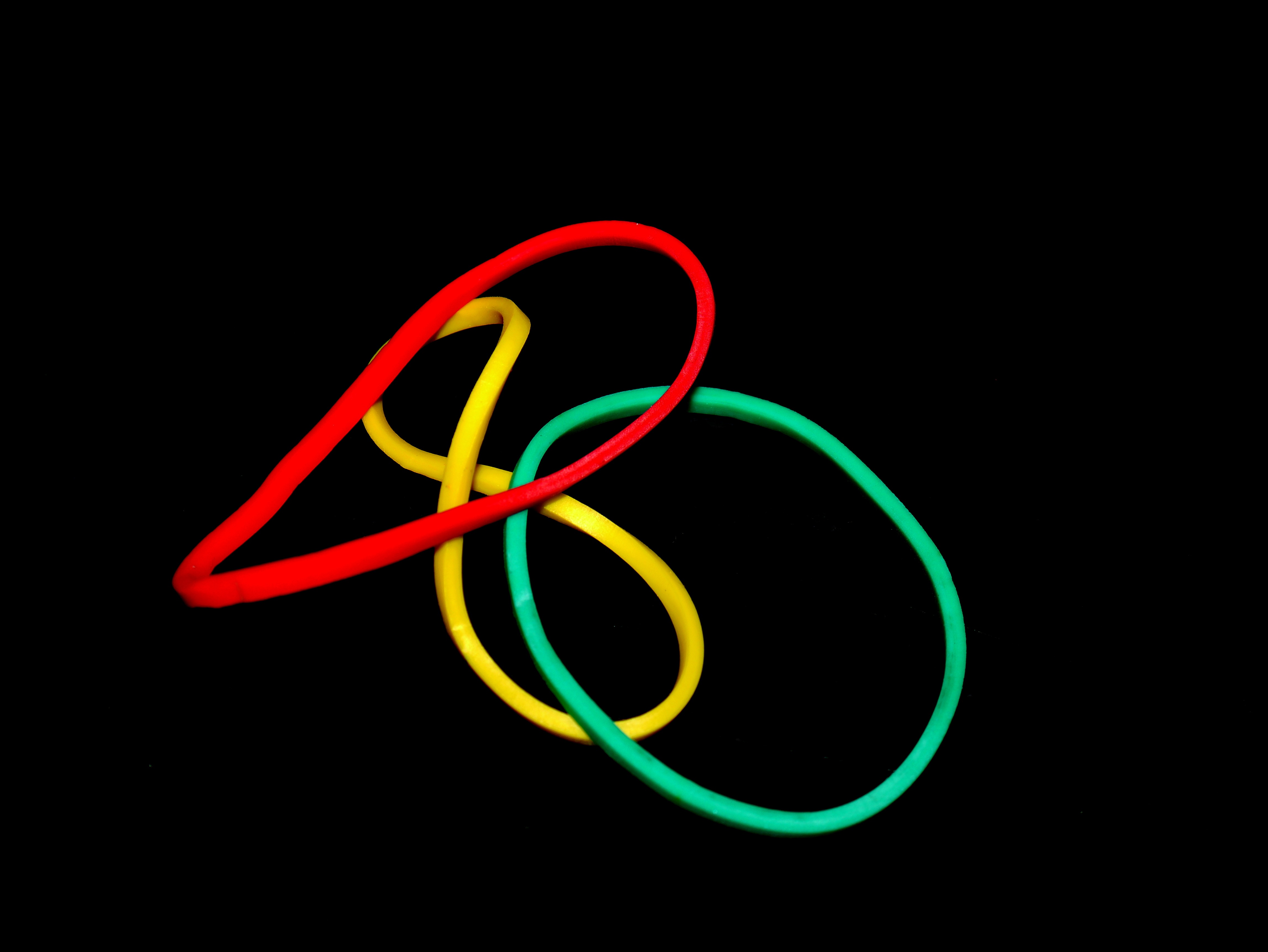 Three Colorful Rubber Bands at black background free image download