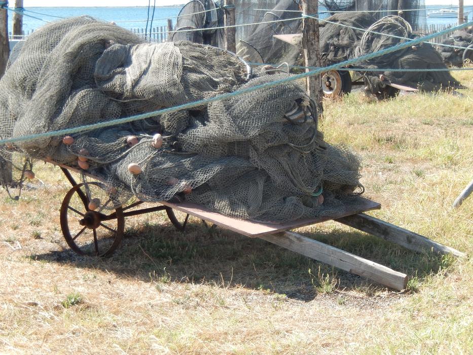 Wheelbarrow with rolled up fishing nets free image download