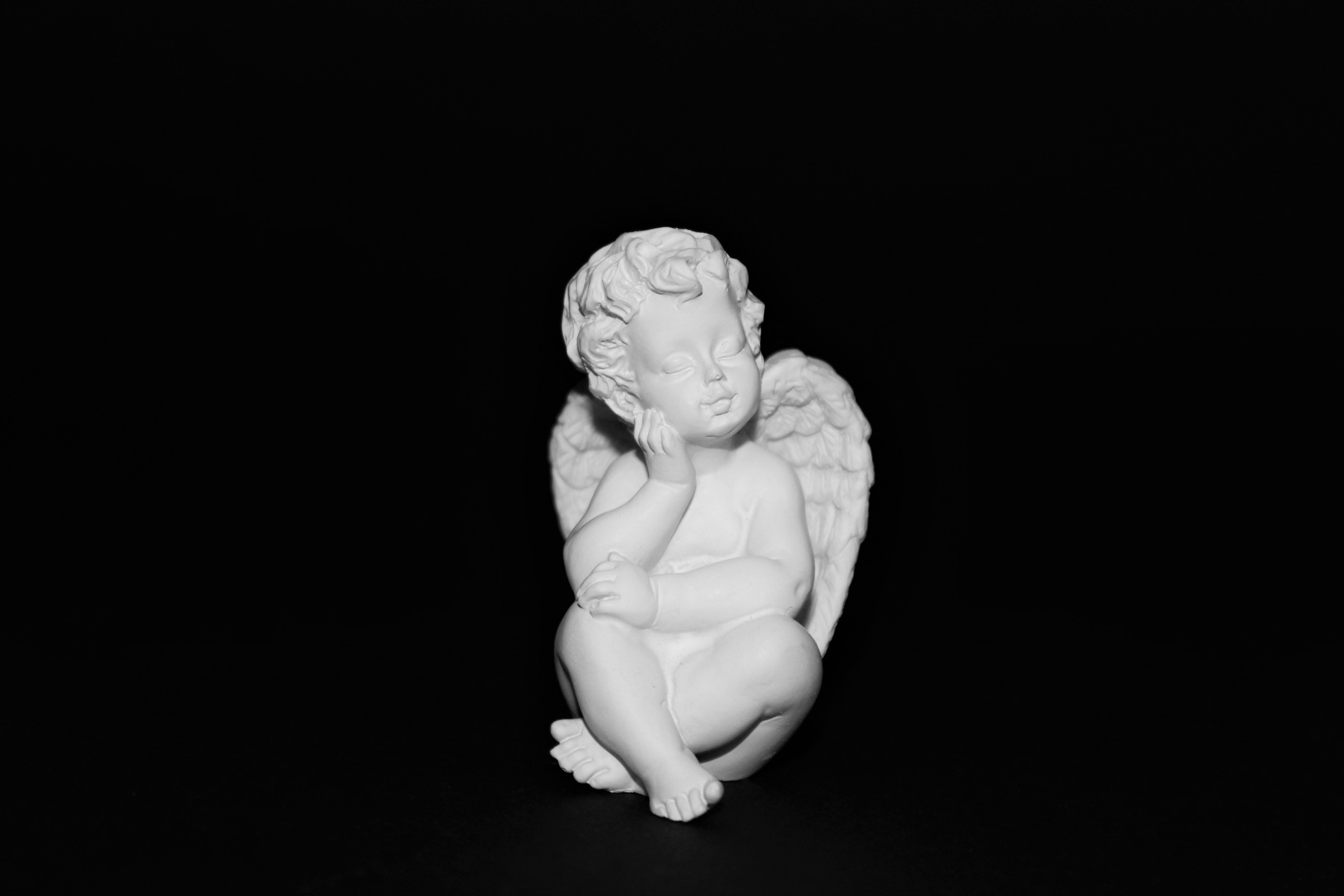 Angel sculpture on a black background free image download
