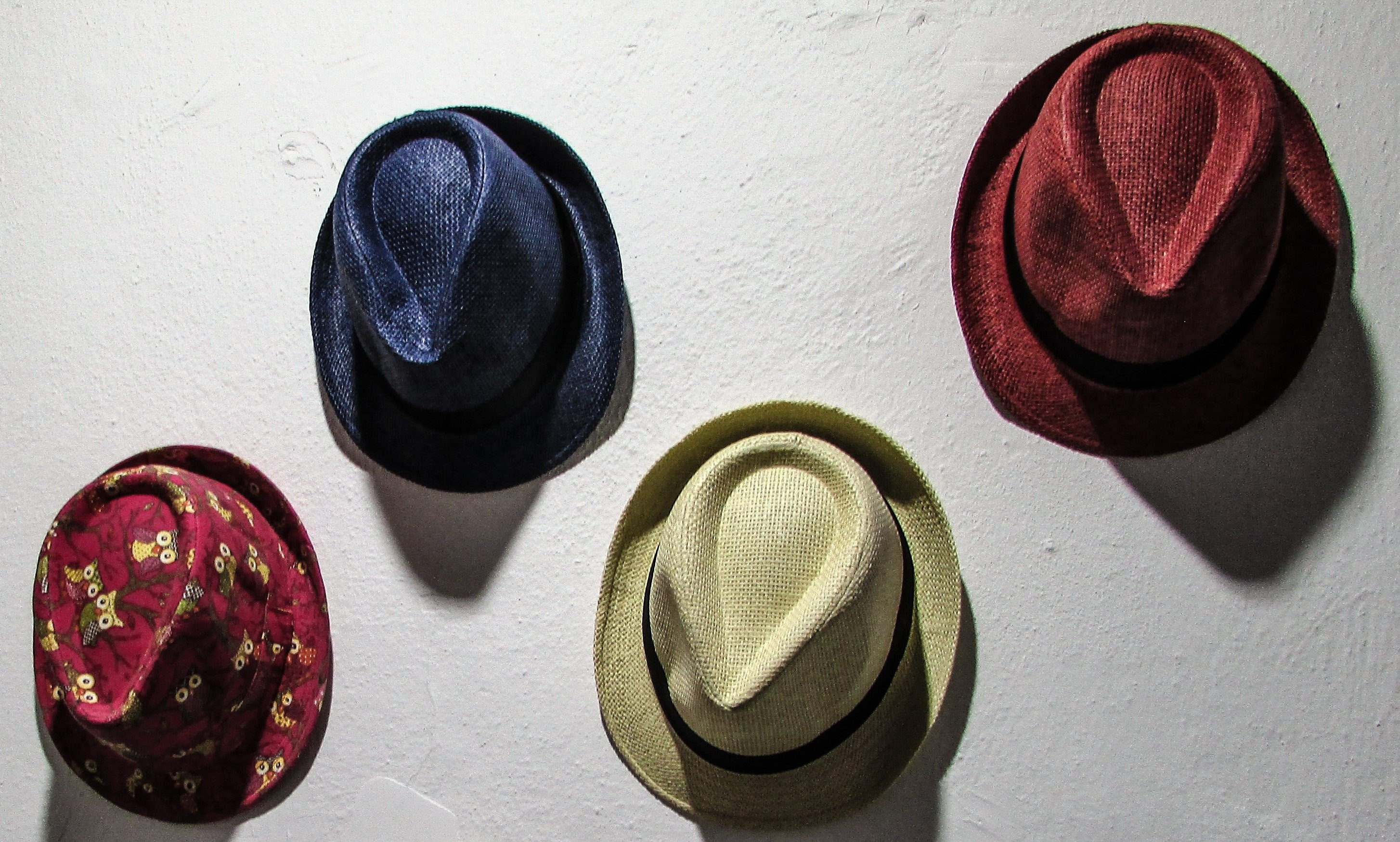 Colored hats on a white wall free image download