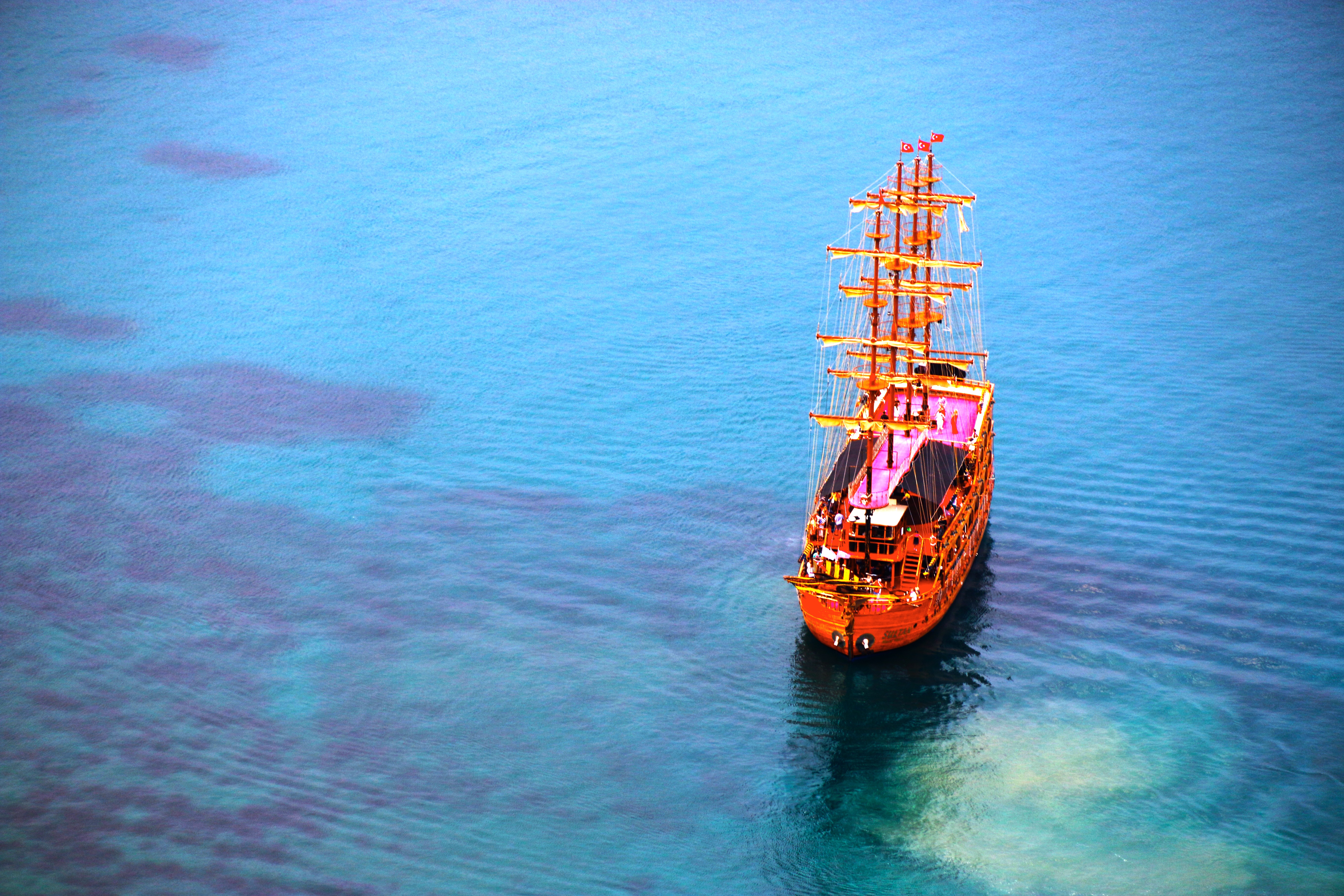 Red ship with sails in the sea free image download