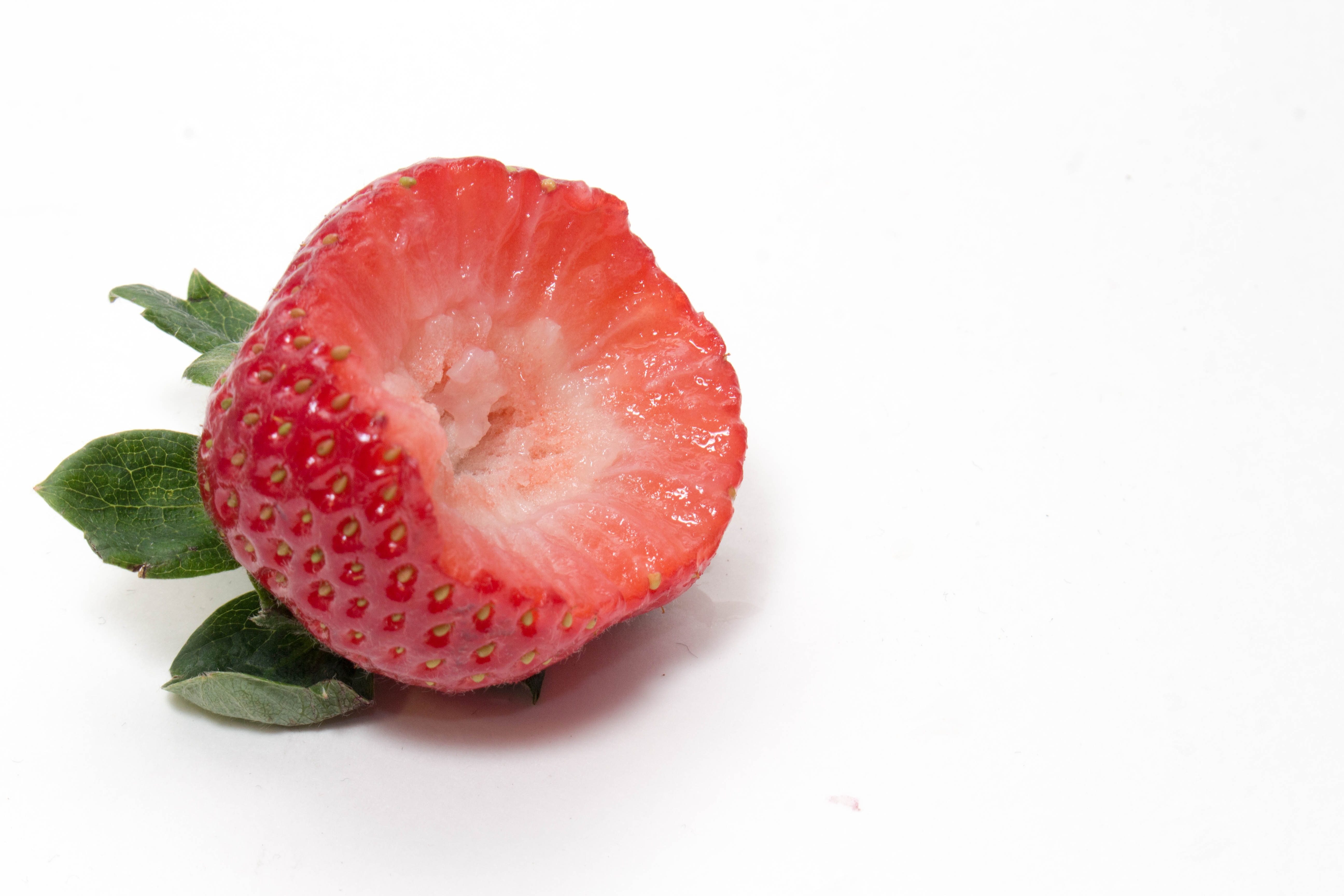 Bitten off strawberries on a white background free image download